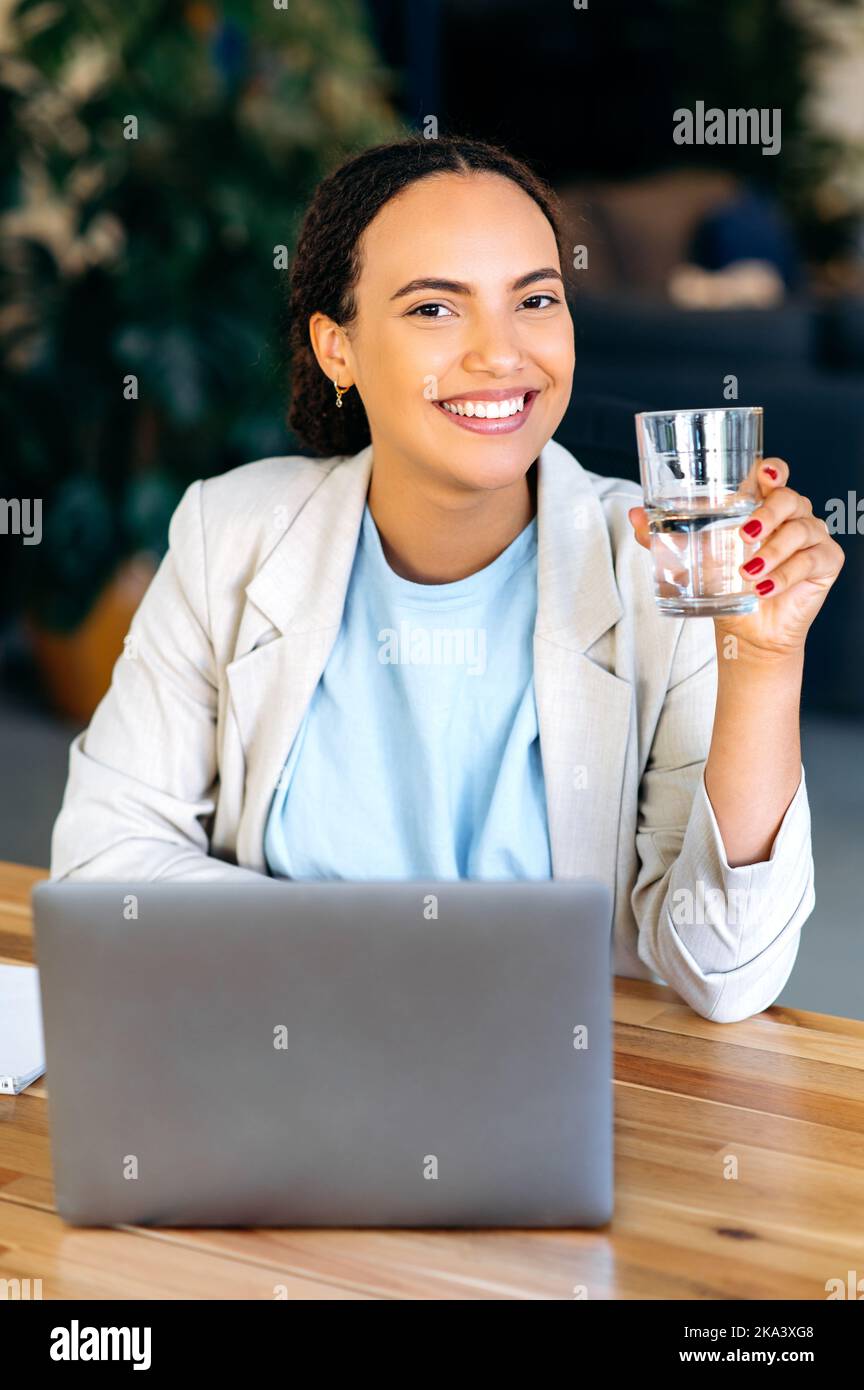 Vertical photo of happy successful positive mixed race female worker ...