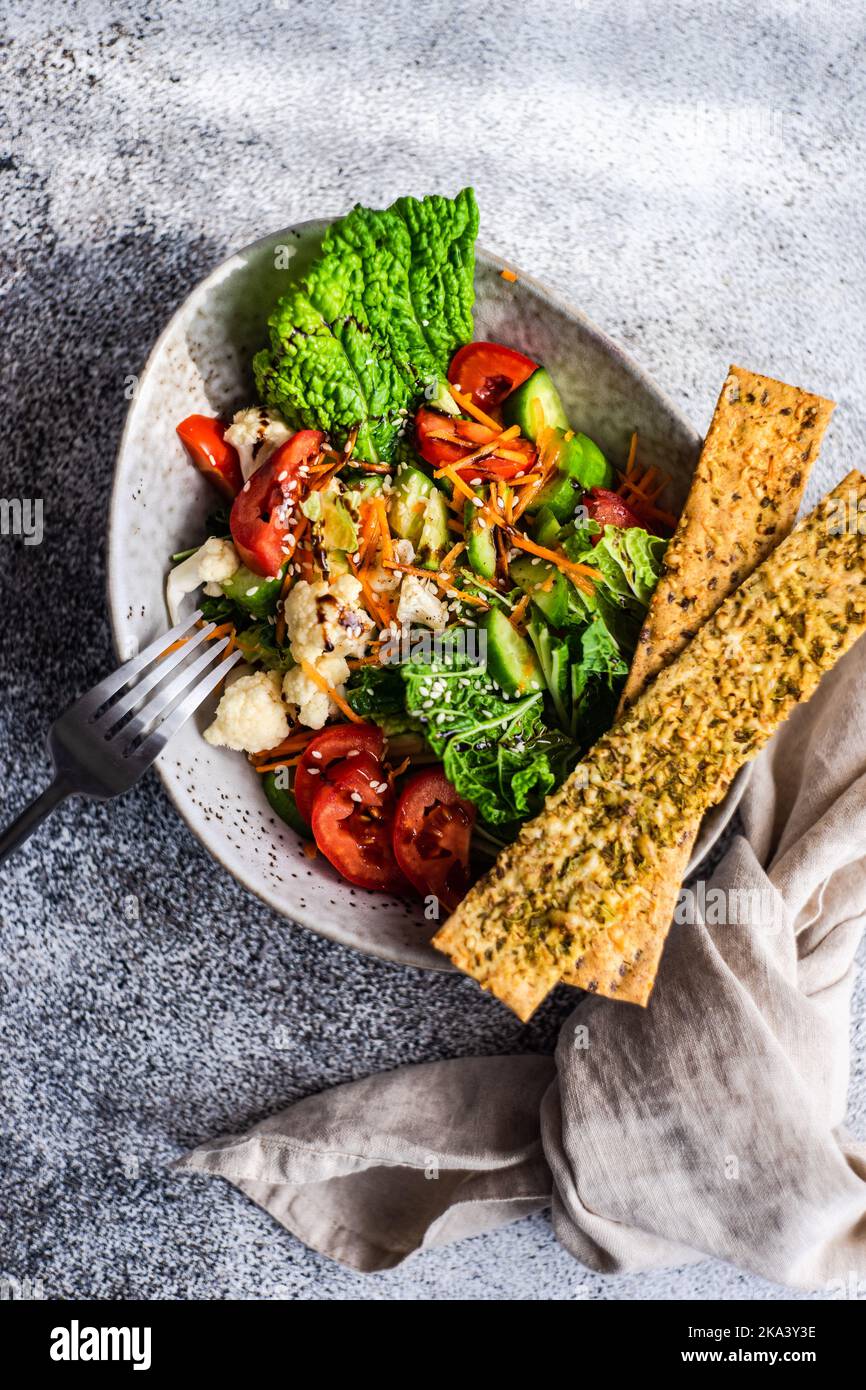 Overhead view of a bowl of salad with lettuce, tomato, cucumber, carrot ...