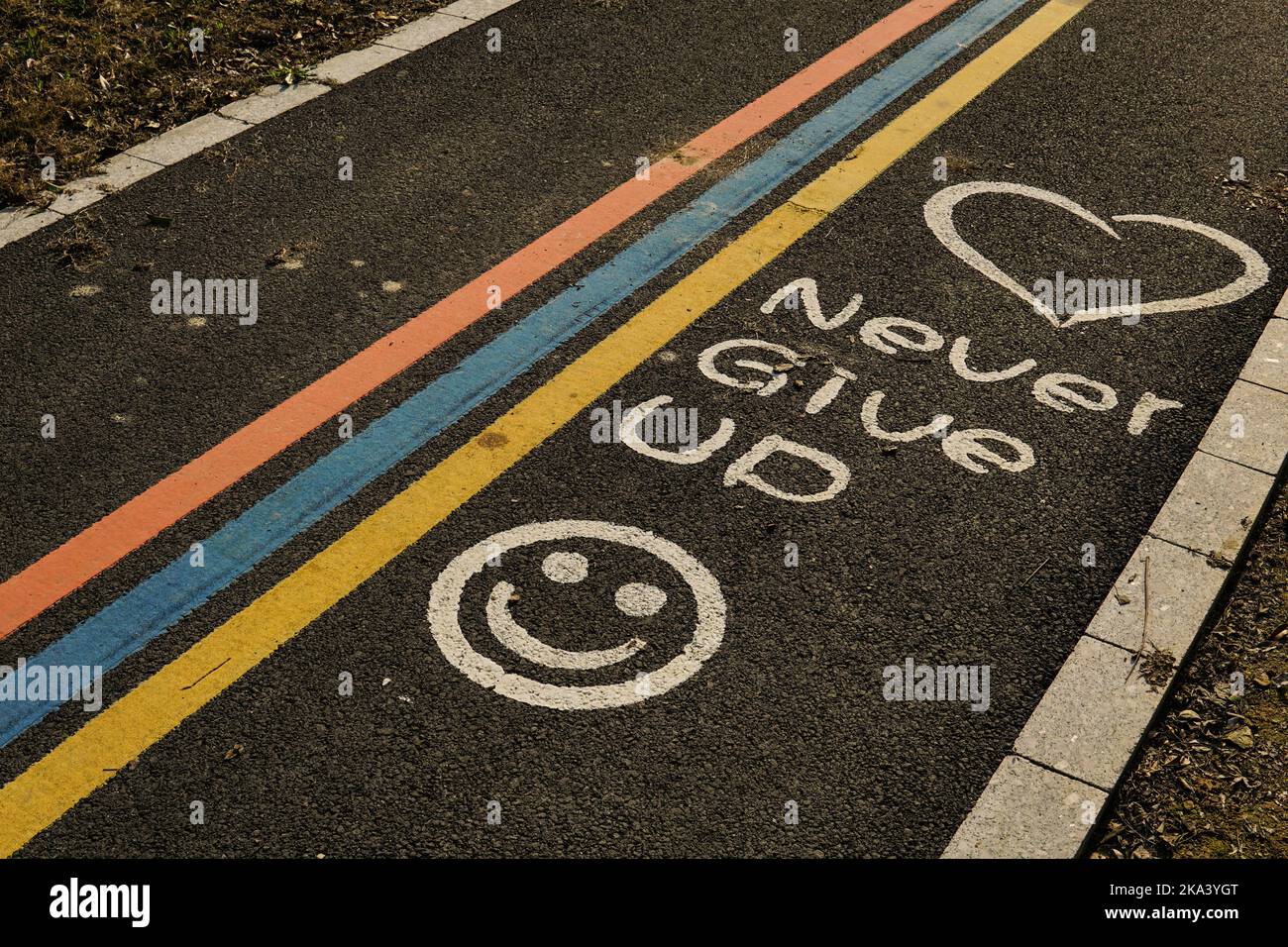 A view of asphalt pavement with red, blue and orange painted lines and ...