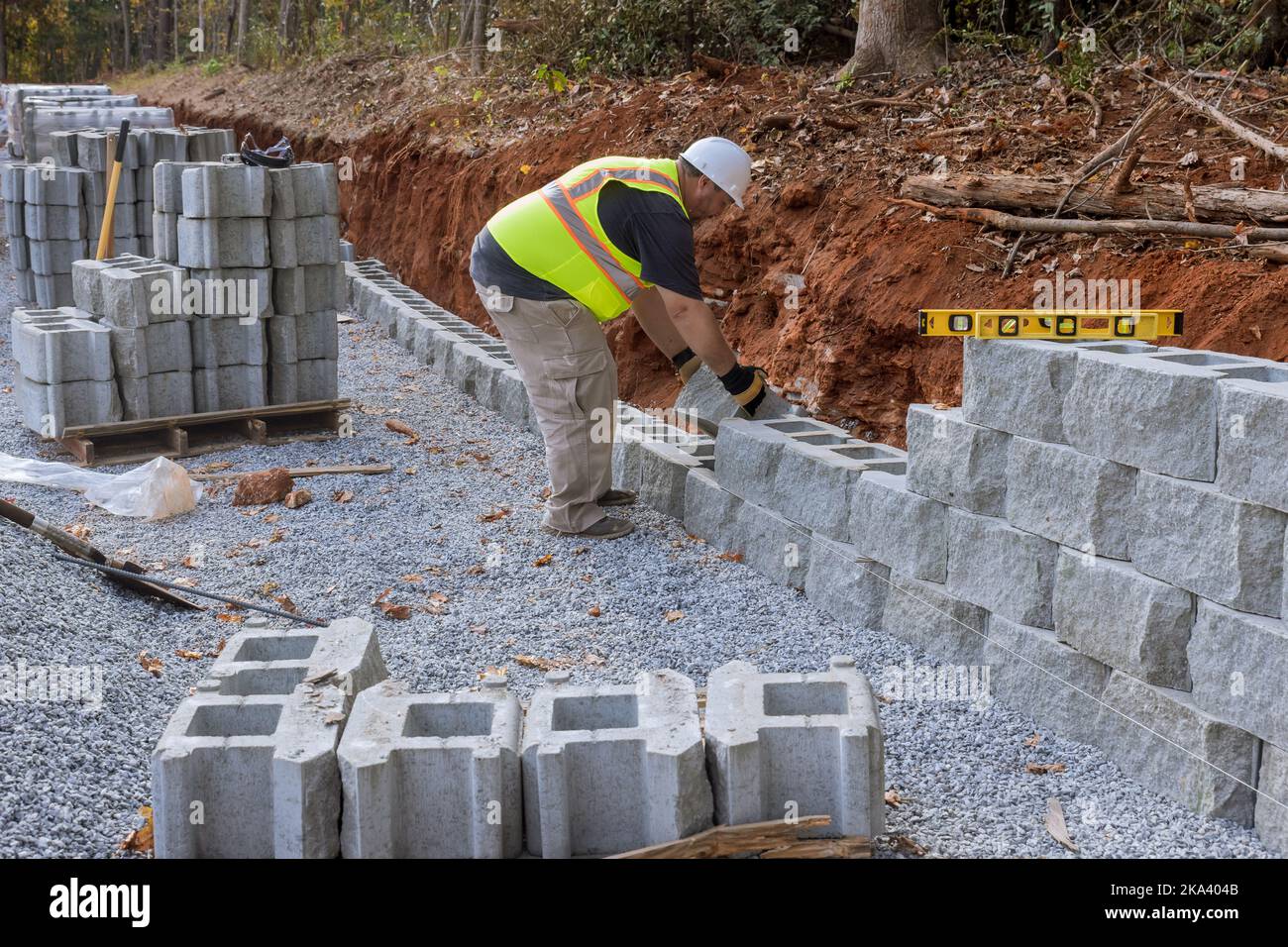 Construction worker is constructing retaining block wall on new ...