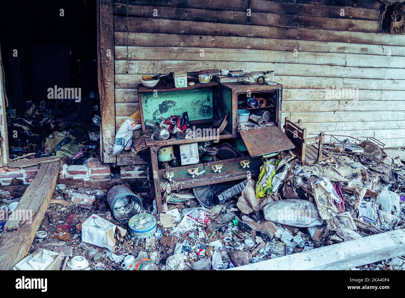 A pile of garbage in front of an abandoned wooden house Stock Photo - Alamy