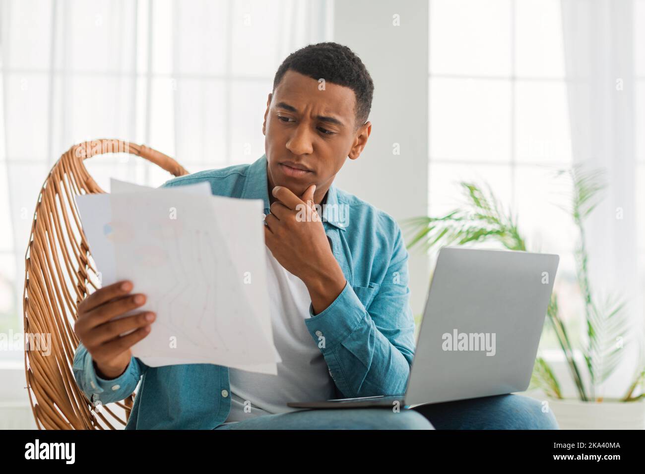 Pensive young african american male working with contract, documents ...