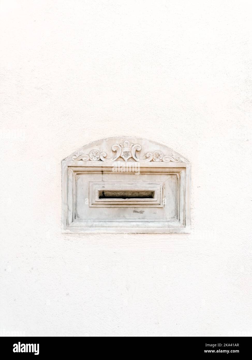 A vertical shot of a historic stone post box on a white wall Stock ...