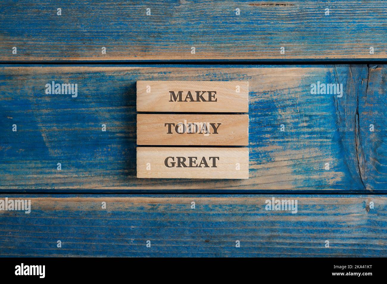 Make today great sign written on three stacked wooden pegs placed over ...