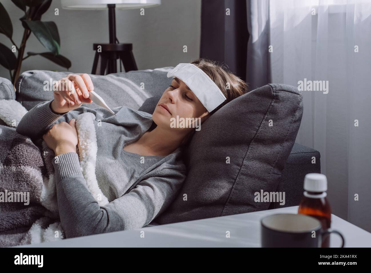 Woman under plaid feel sick unwell. Unhealthy young female measuring ...