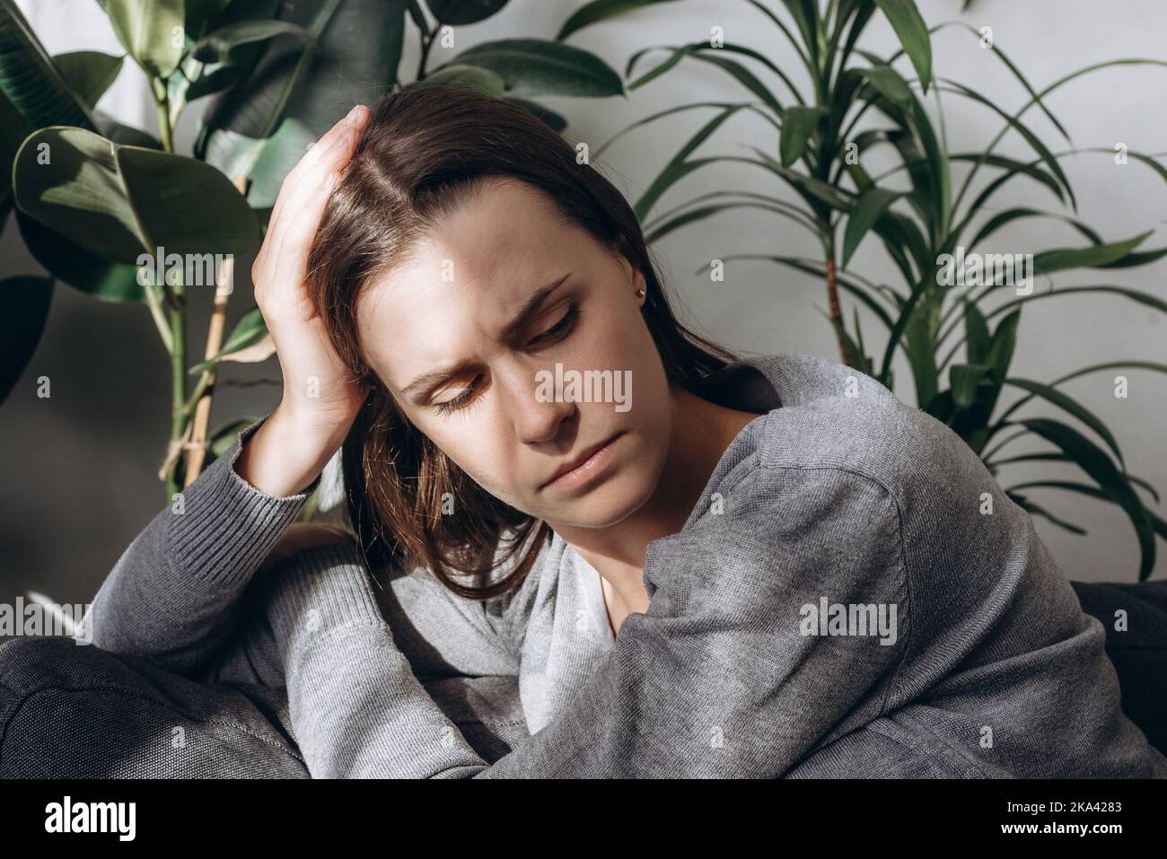 Trouble, stress concept. Pensive young caucasian woman sit on sofa look ...