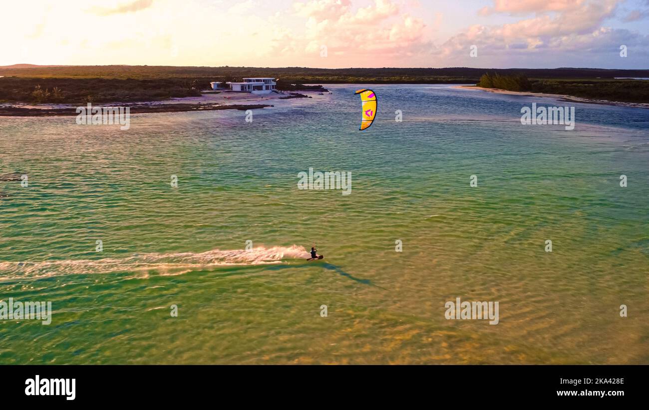 An aerial drone shot of the shallow water and a kitesurfer surfing ...