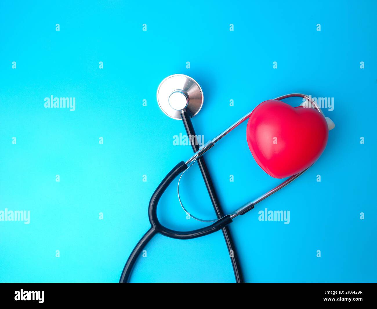 A top view of a stethoscope and a red heart isolated on a blue ...