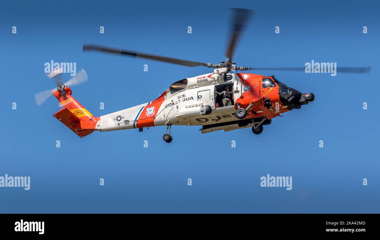 A beautiful shot of a US Coast Guard helicopter in the blue sky at ...