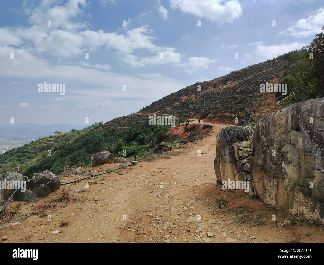 A pathway and rough rocks in hilly terrain Stock Photo - Alamy