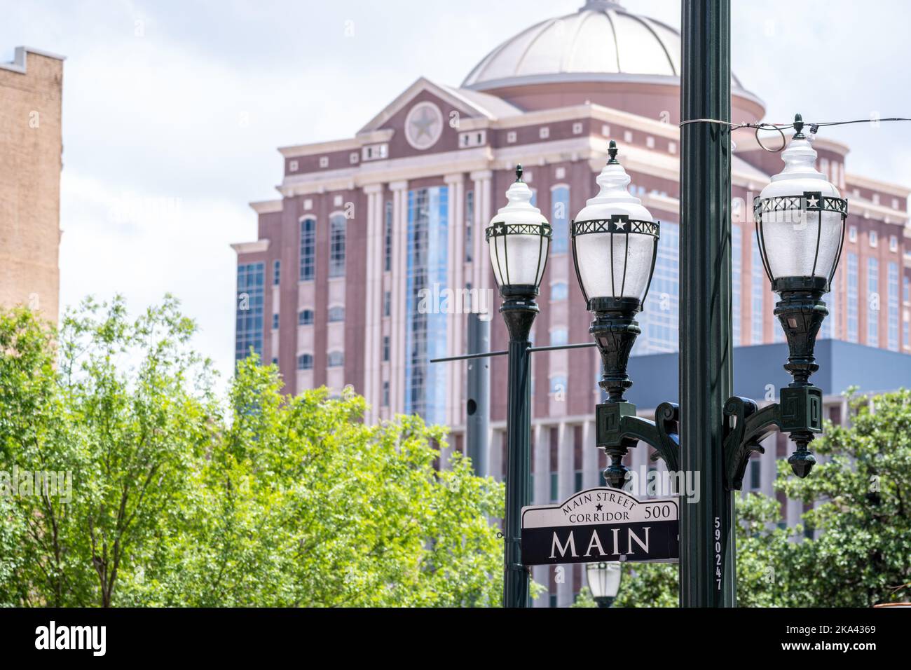 A "Main" street sign in Downtown Houston in Texas with a big building ...