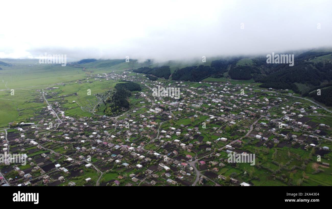 A bird's eye view of a large village on the plain under the ...