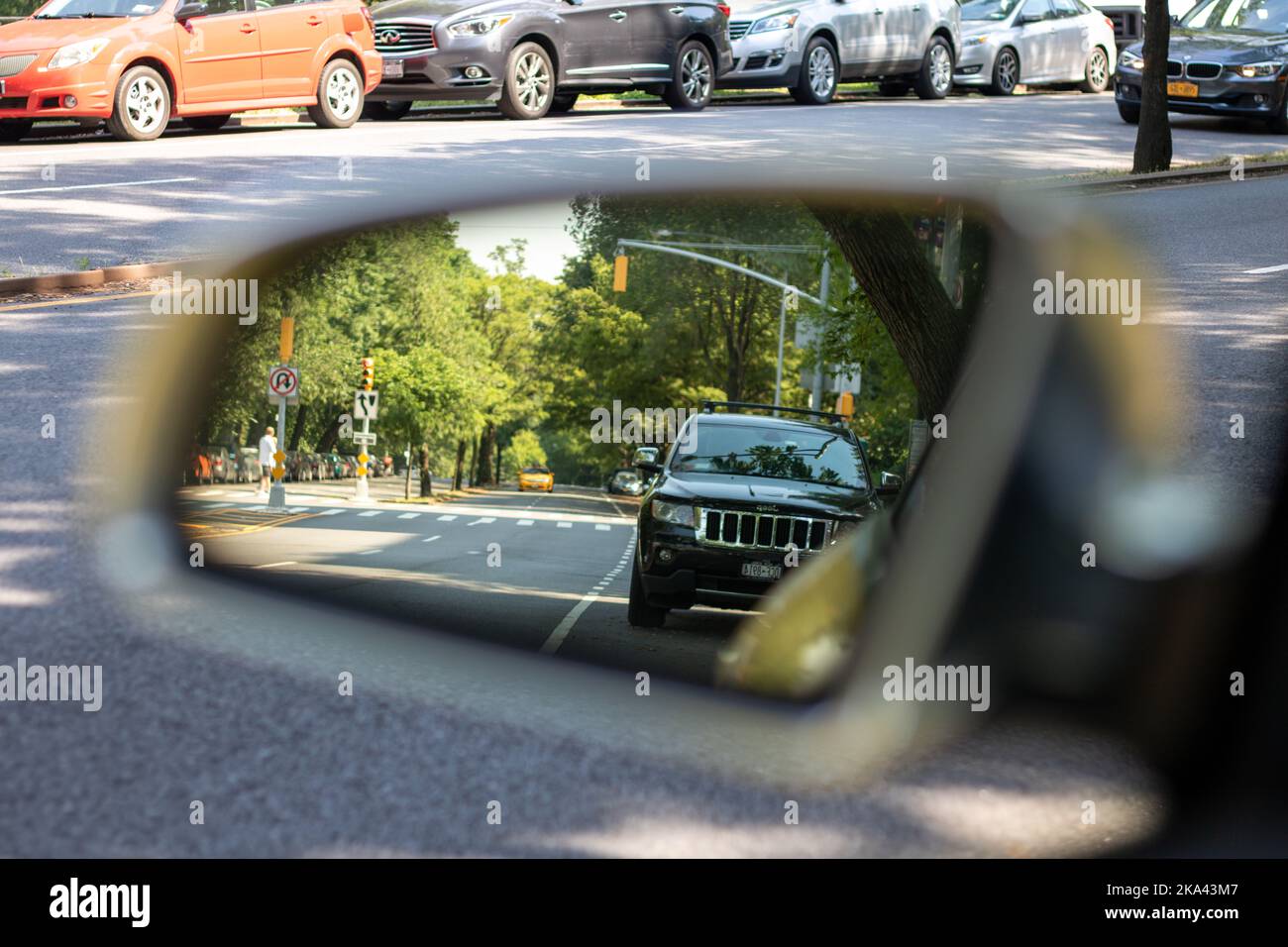 A reflection of traffic through a mirror of a car waiting in line on a ...