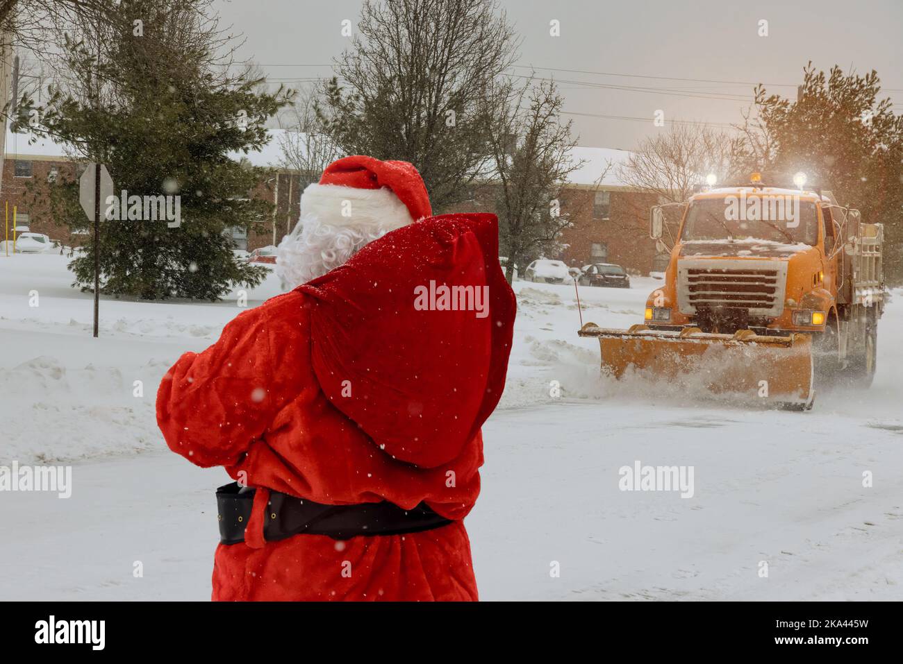 Santa Claus is walking on road with gifts near truck to clear road ...