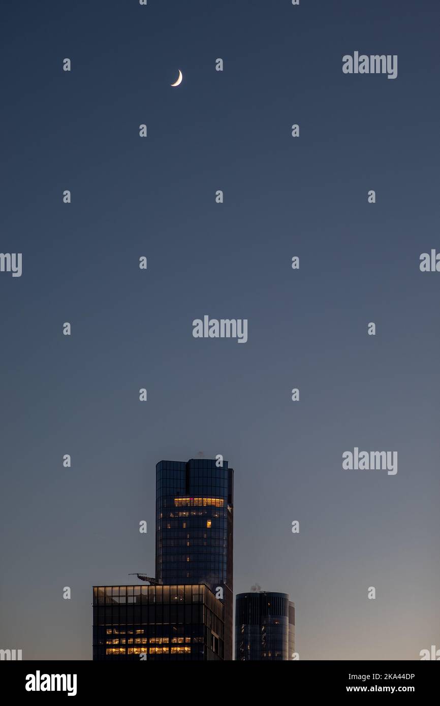 A vertical shot of a crescent moon over New York skyscrapers during ...