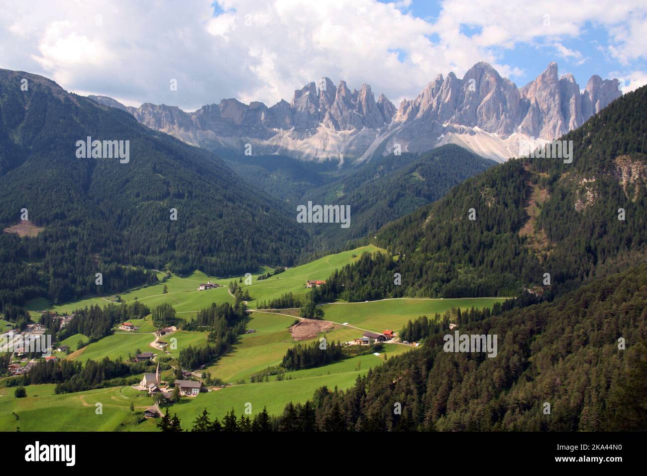 An aerial view of beautiful Dolomites mountains against a blue cloudy ...