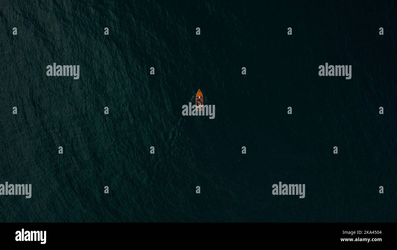 A top view of a little orange rowboat in the middle of the ocean Stock ...
