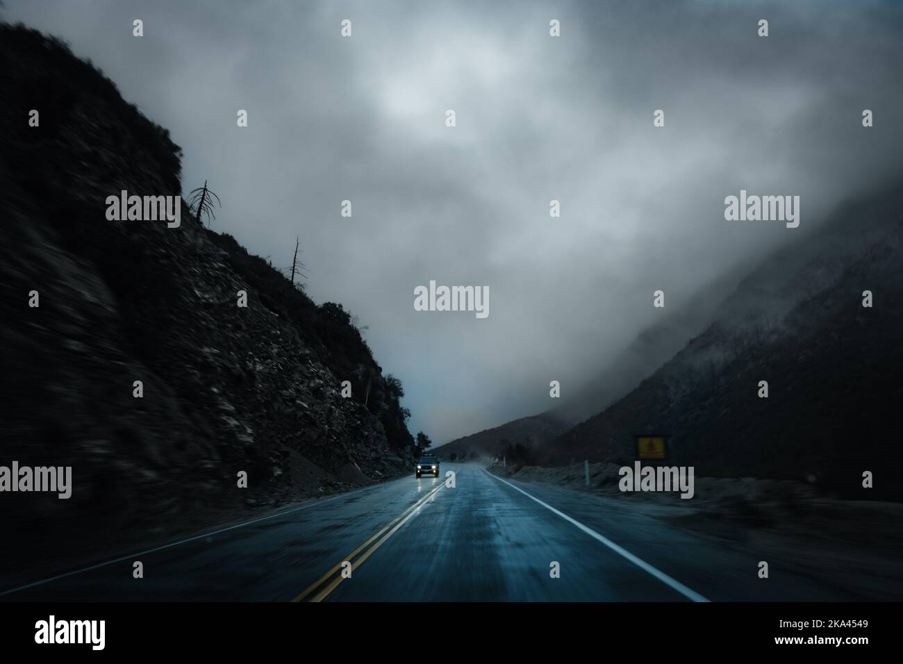 A view of mountain road with car in drive in foggy day Stock Photo - Alamy