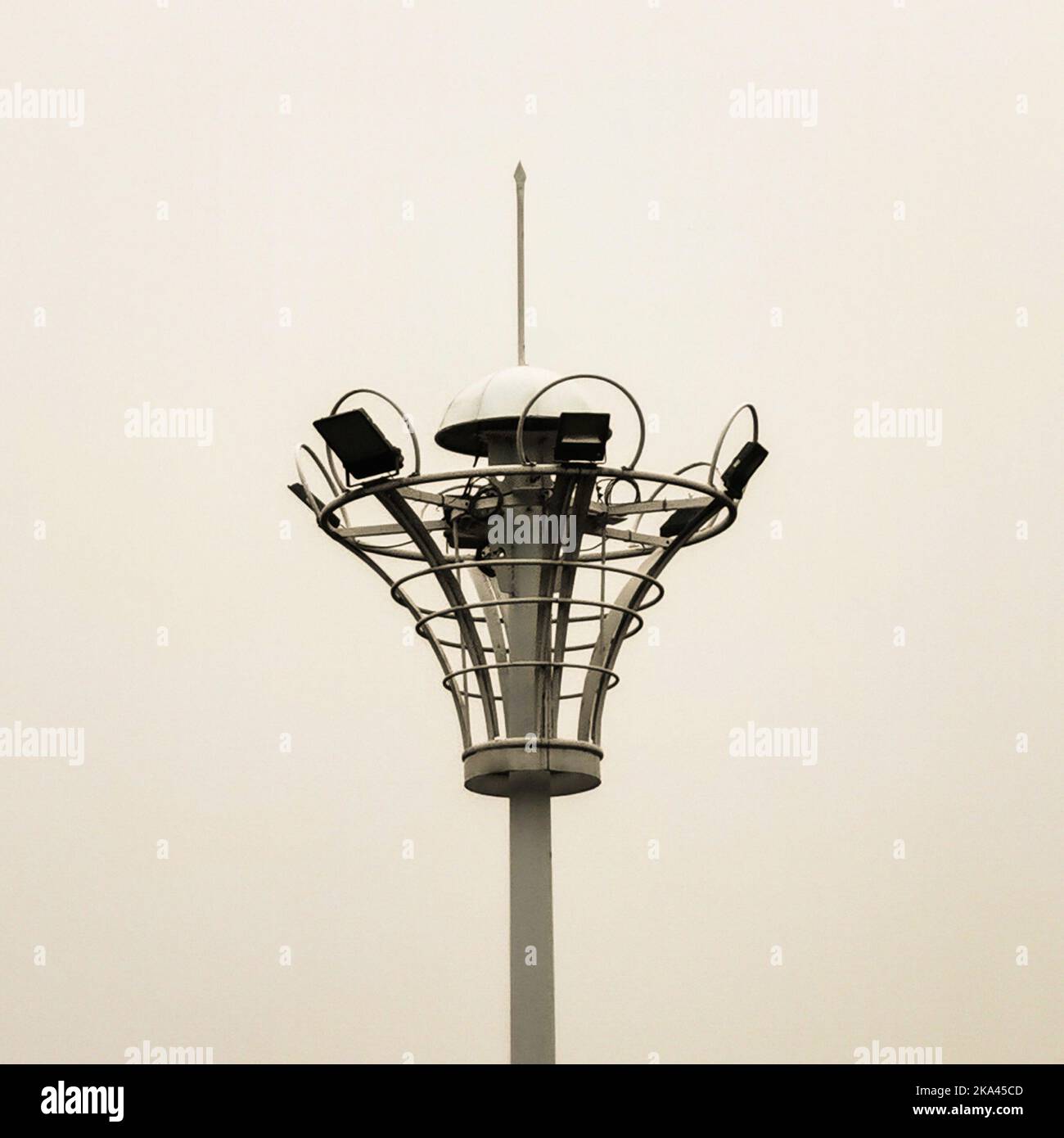 A view of a gray street light tower made of metal on plain white ...