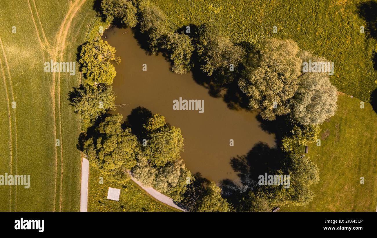 A top view shot of a small lake surrounded by trees in Upper Austria ...