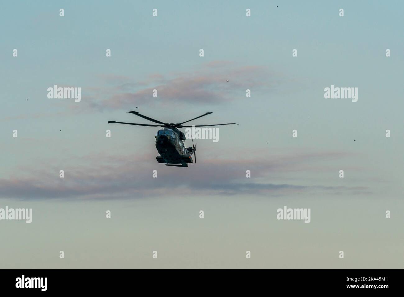 A scenic view of a helicopter flying high in the cloudy sky background ...