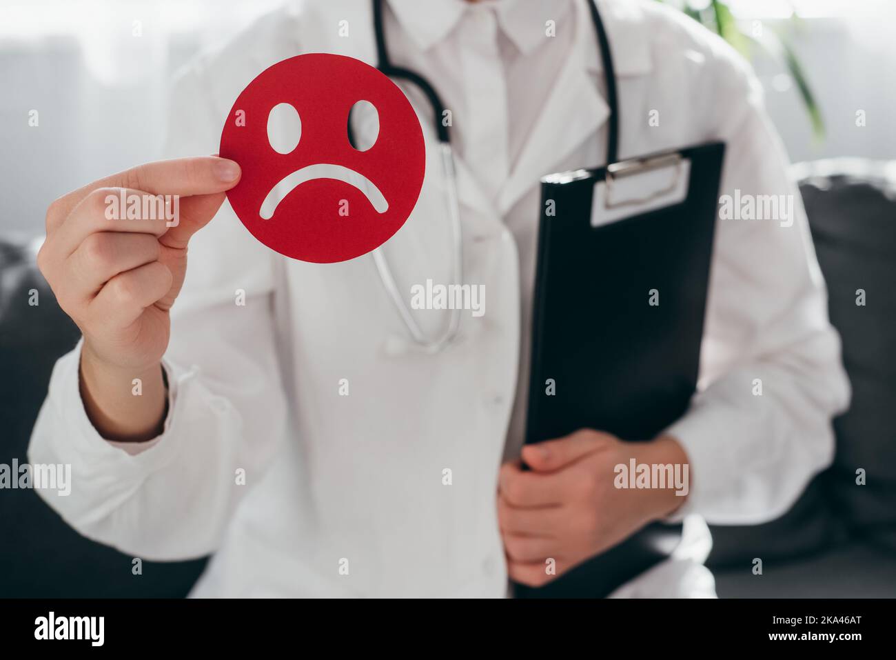 Woman doctor in white uniform with stethoscope holding little red angry ...
