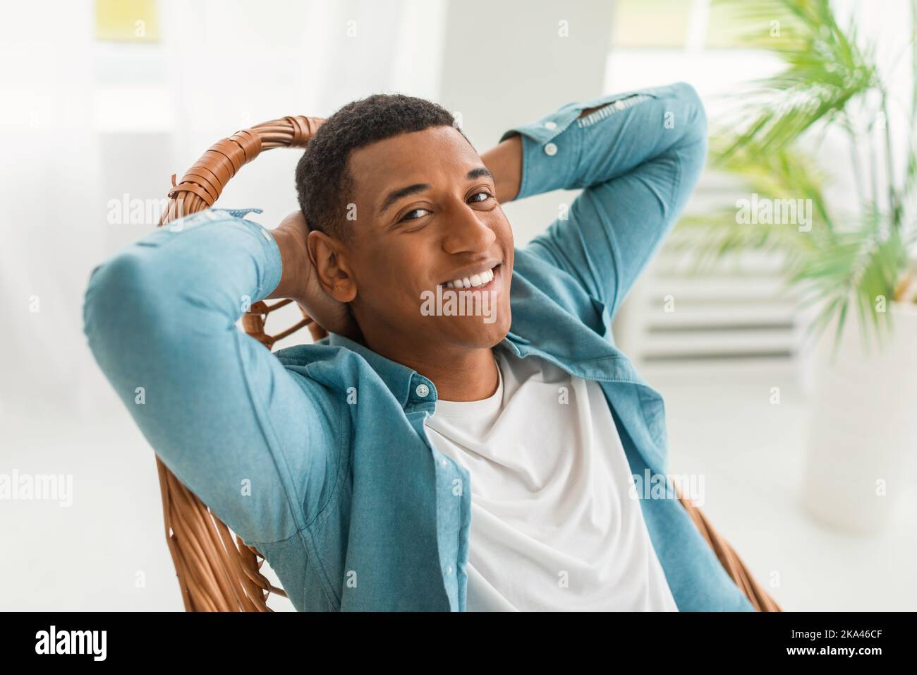 Cheerful handsome millennial african american male resting on chair ...