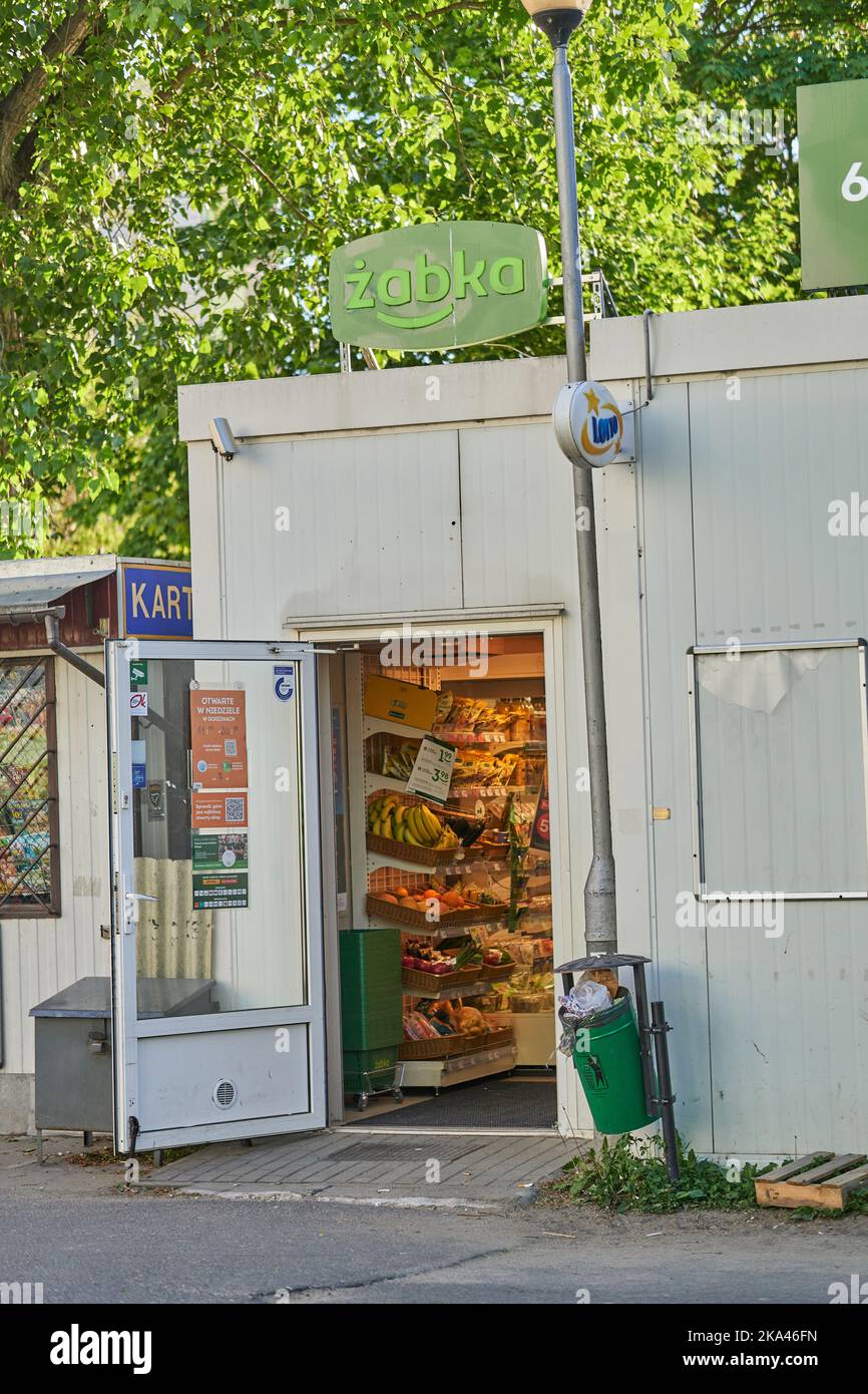 A vertical shot of a small Zabka grocery store with open door in the ...