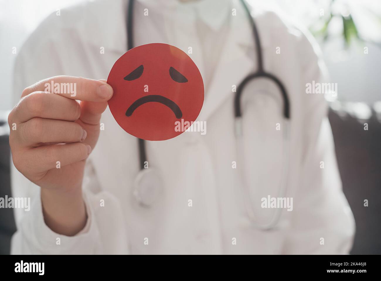 Female doctor in white lab uniform with stethoscope holding little red ...