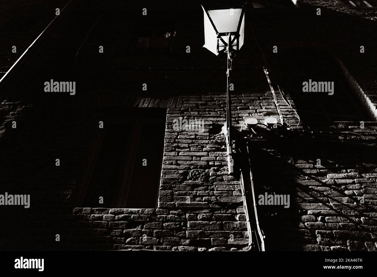 A low angle of a street light and electricity cables on a stone brick ...