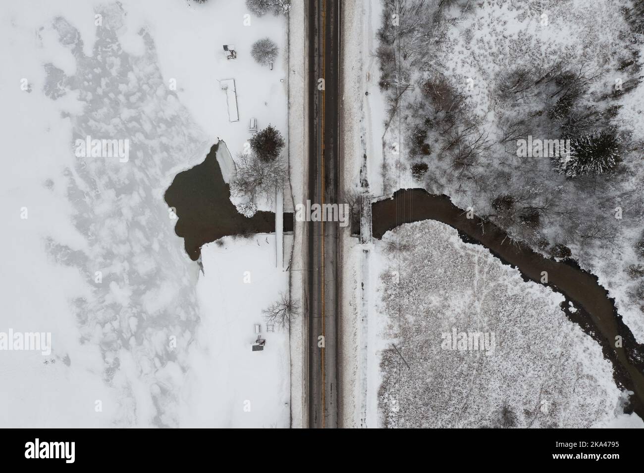 A top view of a road stretching through a white area covered with snow ...