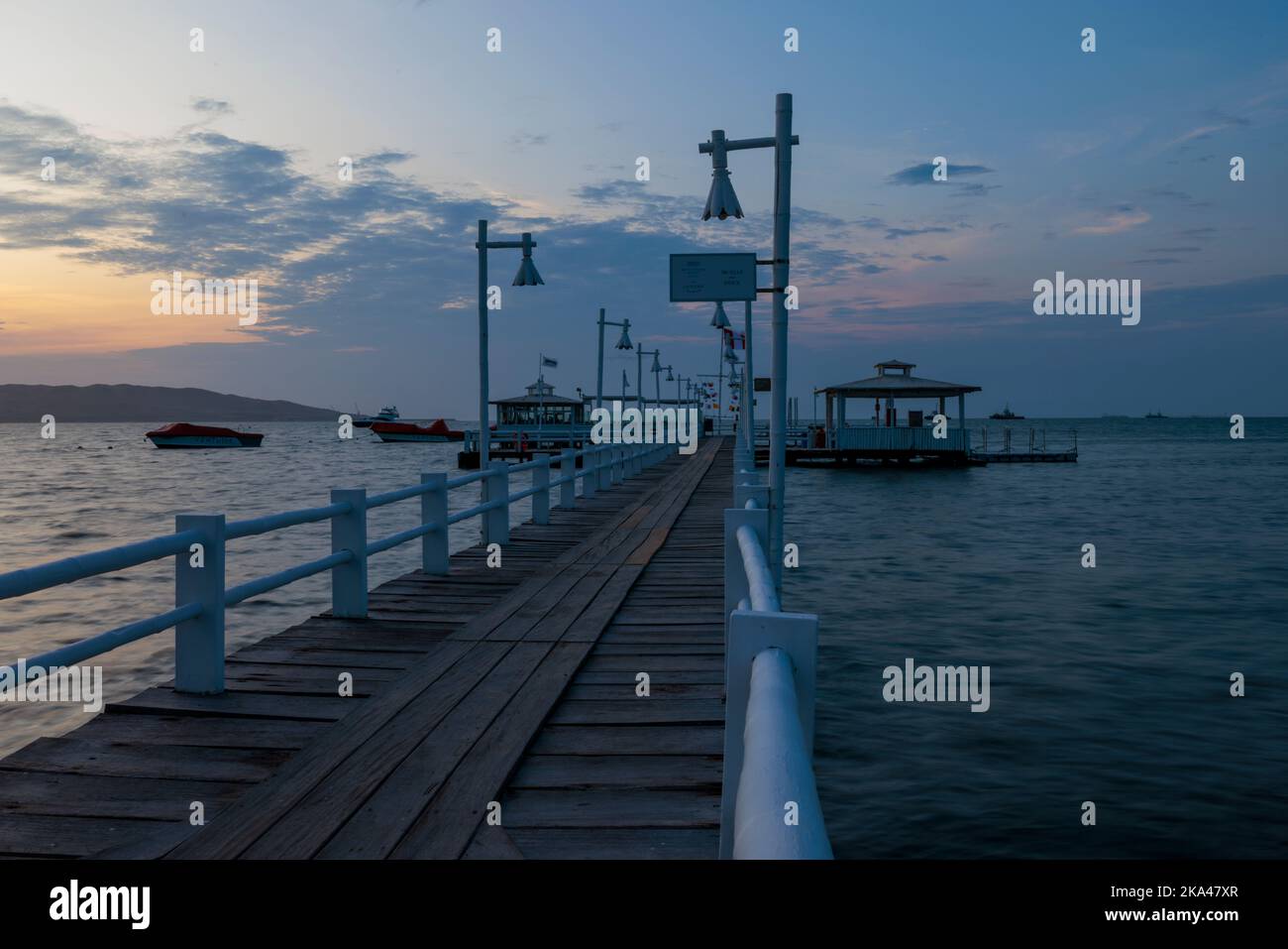 A pier with a view of the ocean in Paracas, Peru at sunset Stock Photo ...