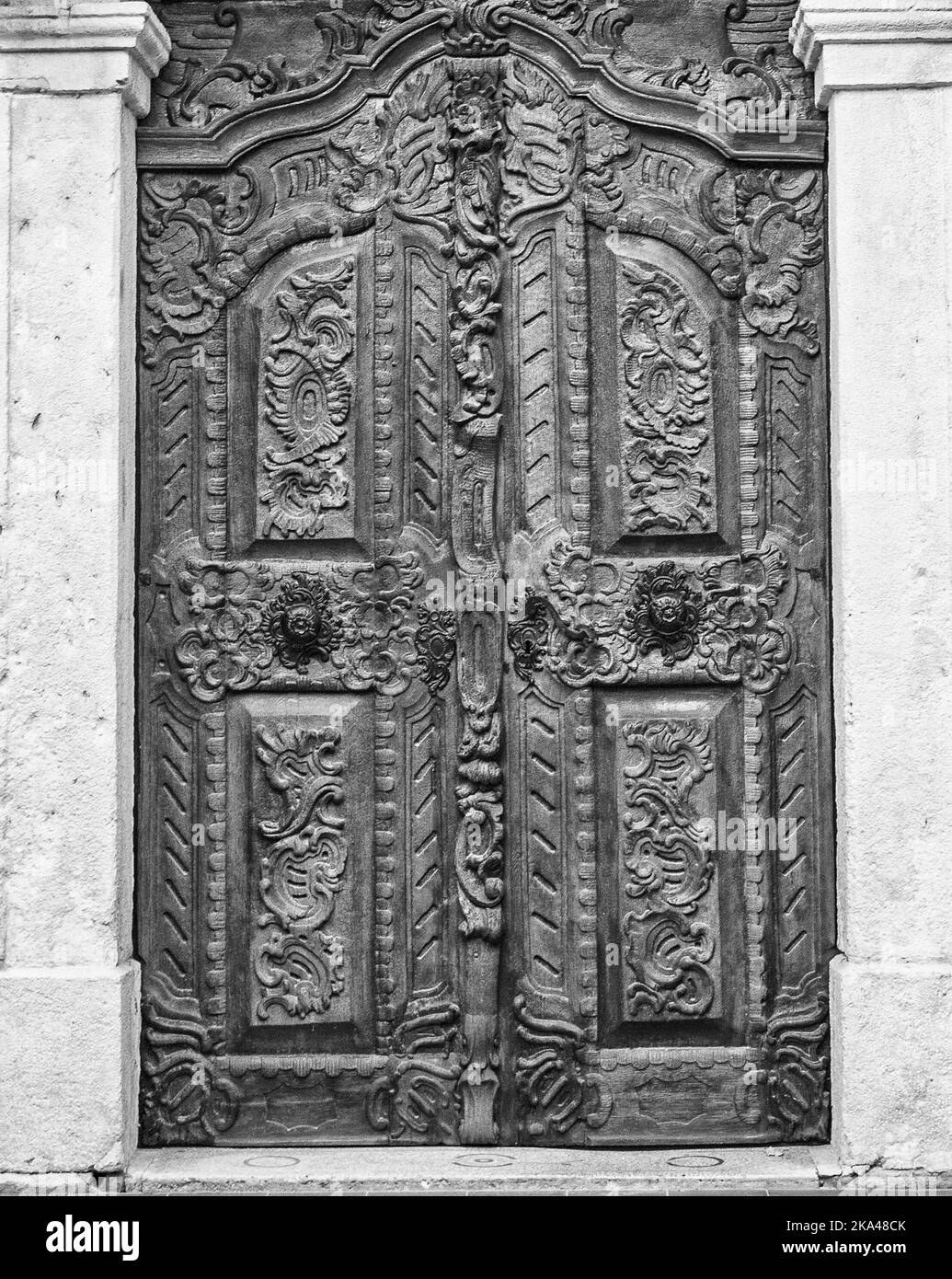 A vertical grayscale shot of an old wooden door in baroque style Stock ...