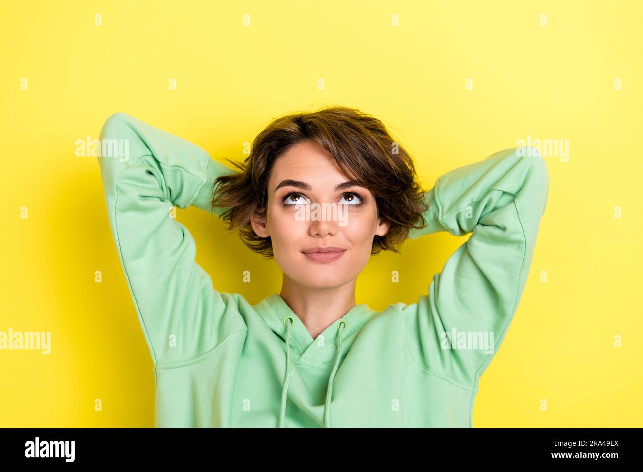 Photo portrait of lovely young lady arms behind head look up empty ...