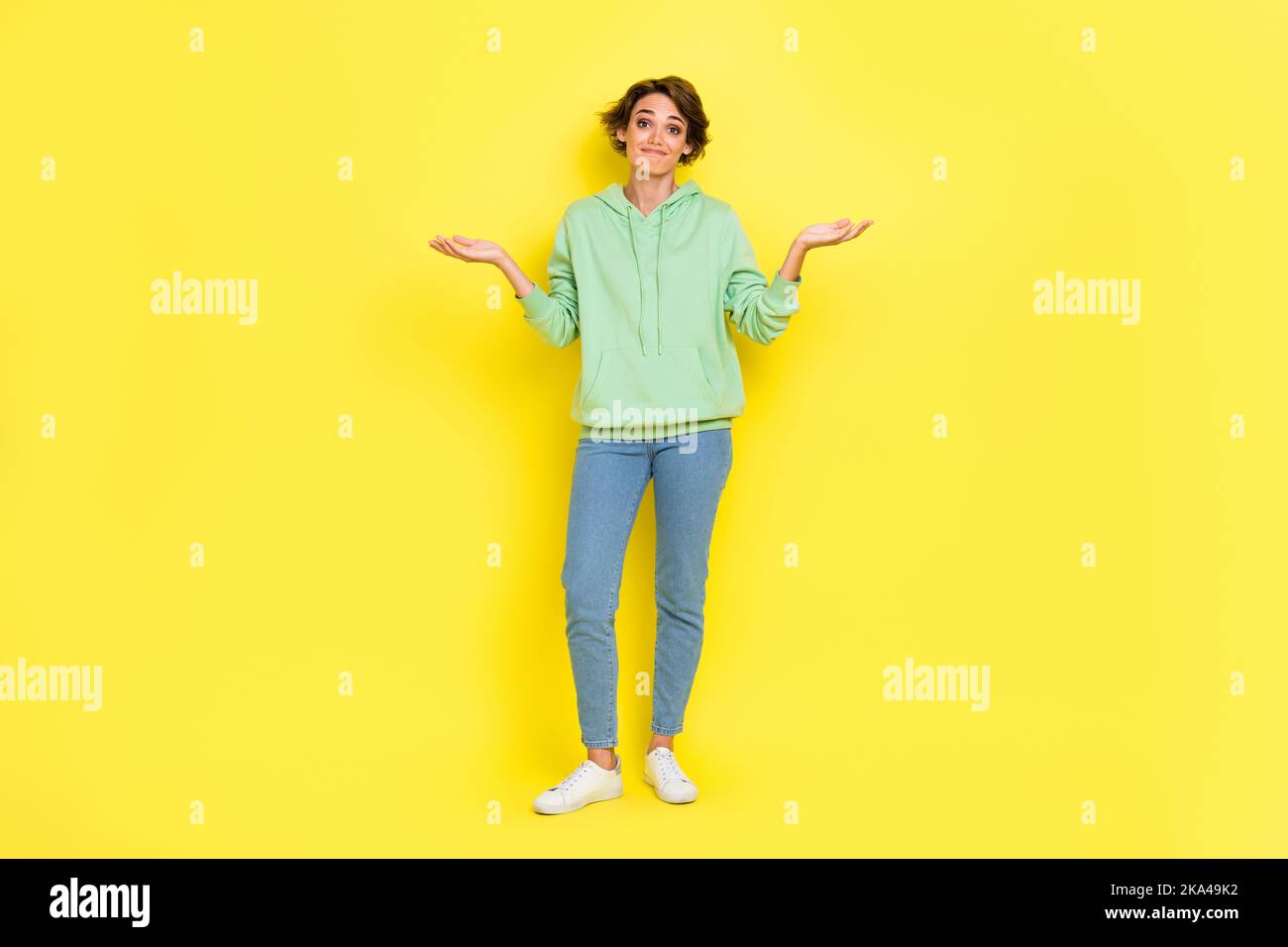 Full length photo of doubtful unsure lady wear green hoodie shrugging ...