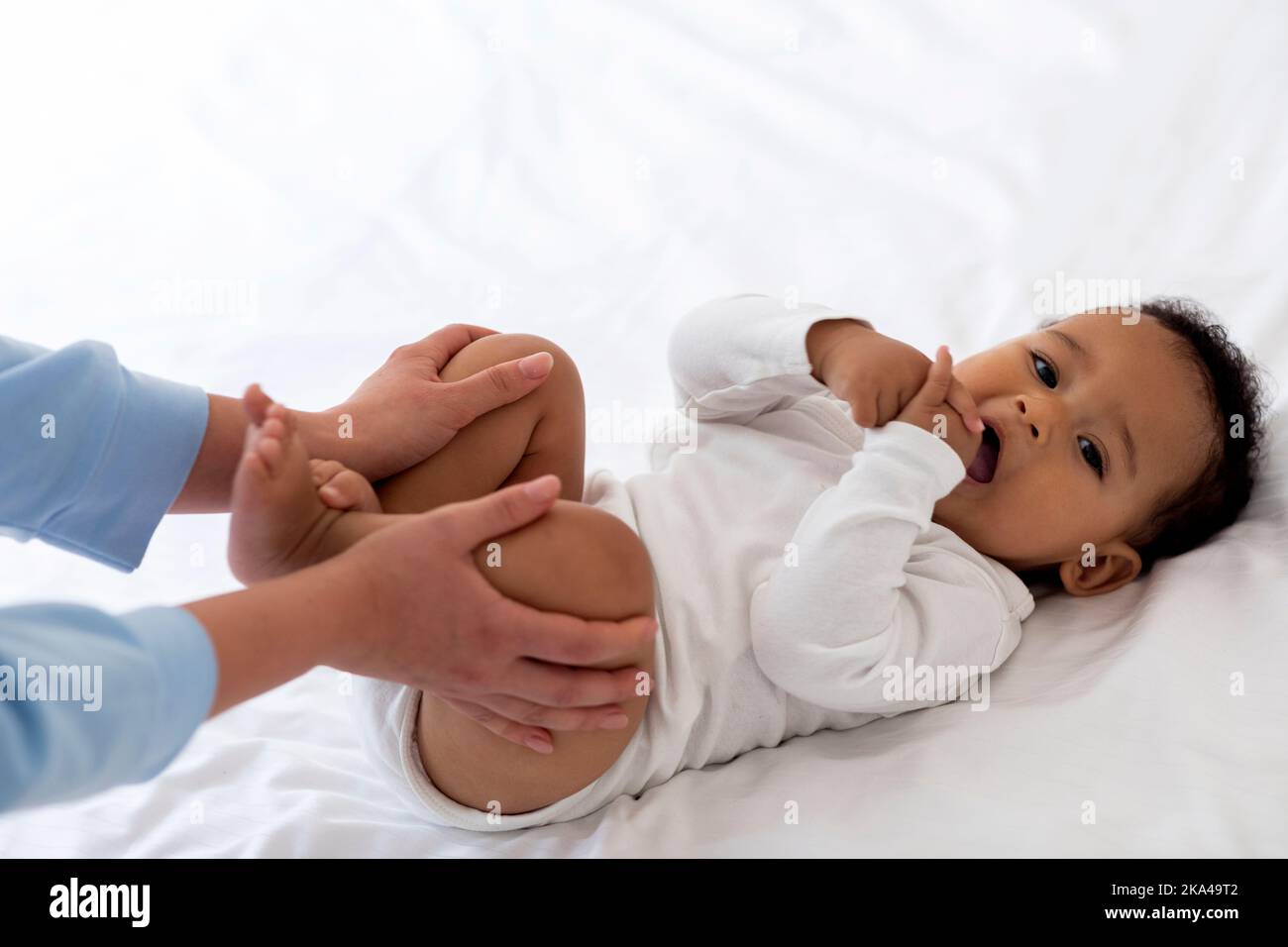 Constipation In Babies. Caring Mother Doing Gymnastics With Black ...