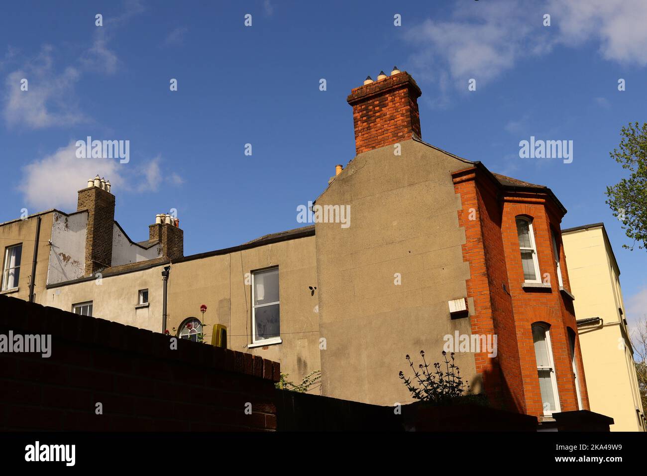 Red brick buildings in Dublin, Ireland with tree, blue sky and clouds ...