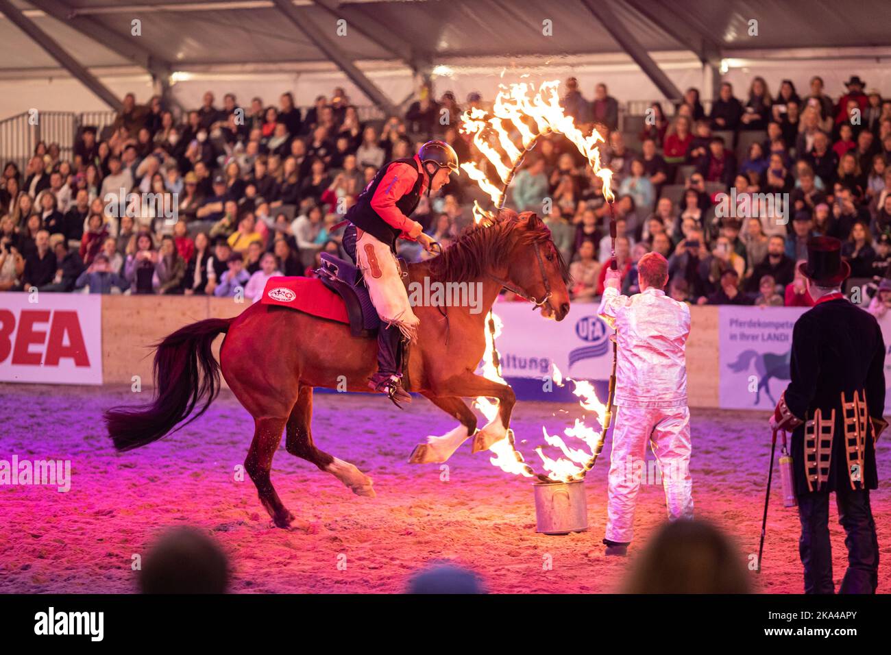 A horseback rider jumping through a fire hoop during the BEA exhibition ...