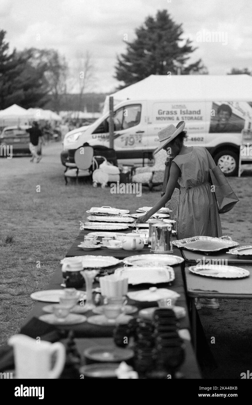 A vertical shot of a woman choosing merchandise in a flea market Stock ...
