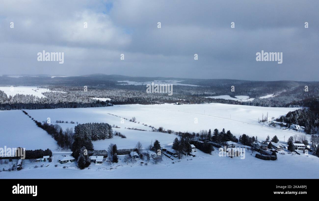 A beautiful view of a snowy landscape with a village and a forest on a ...