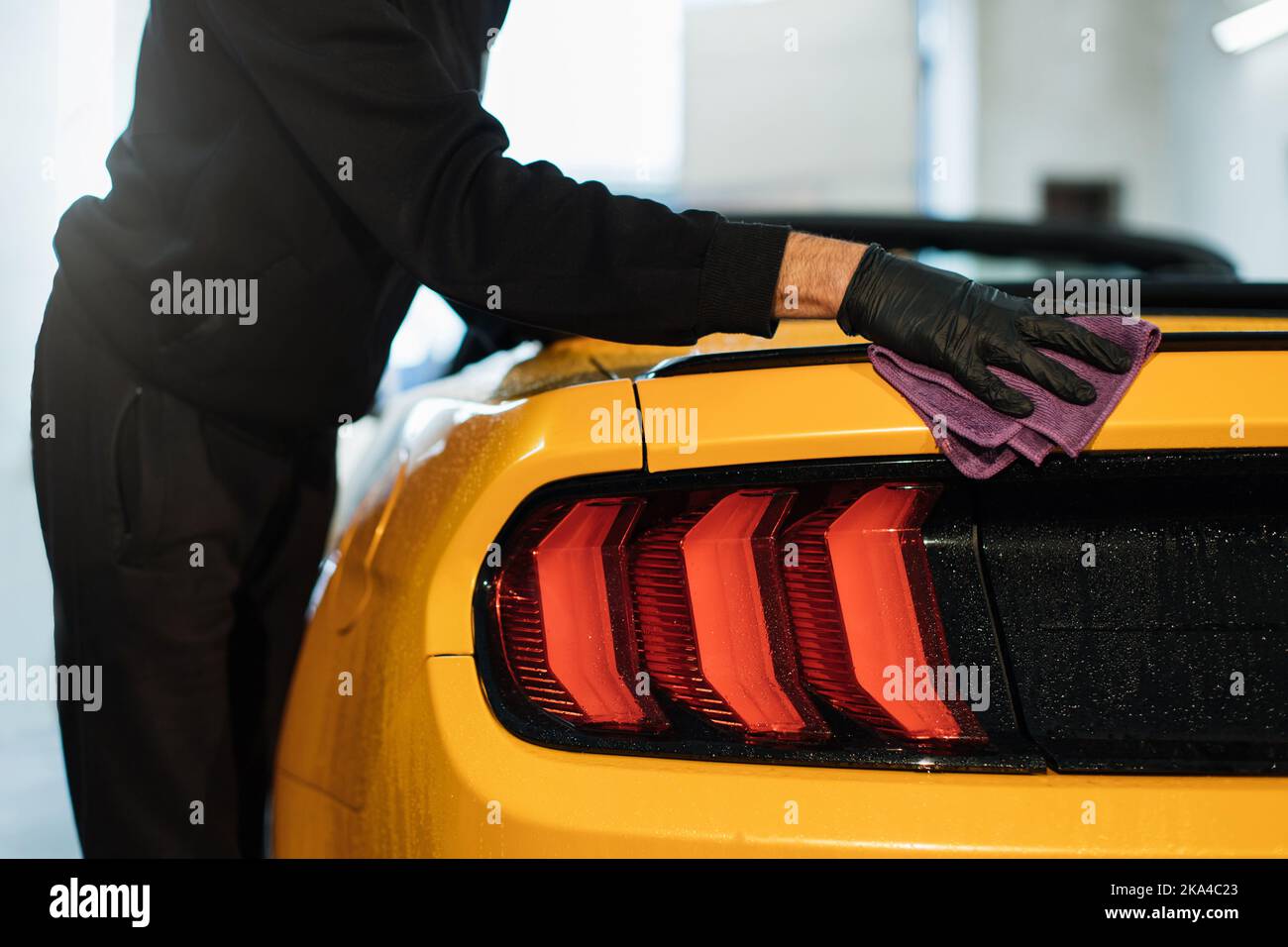 Cropped view of hand of male car wash worker holds the microfiber and ...