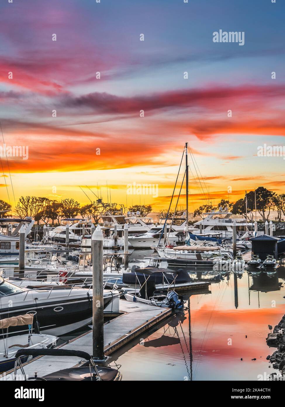 A vertical shot of a bright sunset sky over a seaport village in San ...