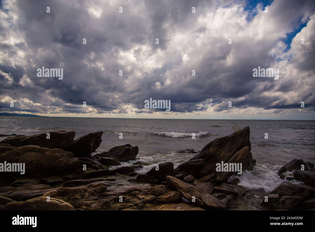 A beautiful scene of rocks on the beach by majestic water in Malawi ...