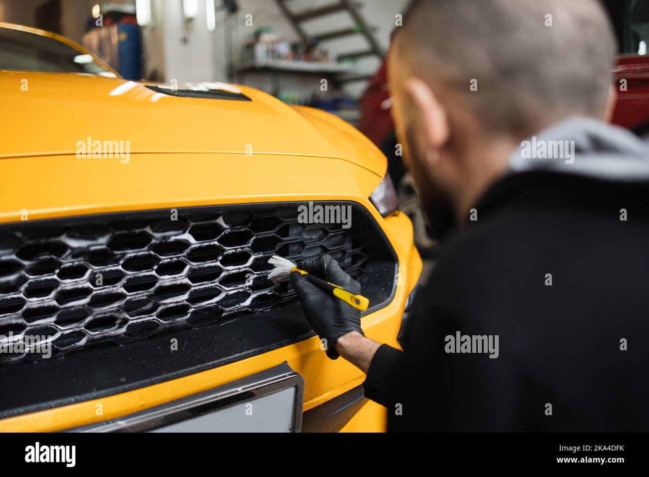 Car detailing wash. Manual cleaning with soap at car wash. Portrait of ...