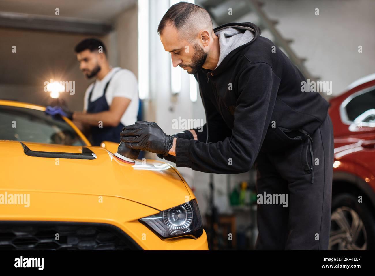 Auto detailing service, polishing of the car. Team of young men workers ...