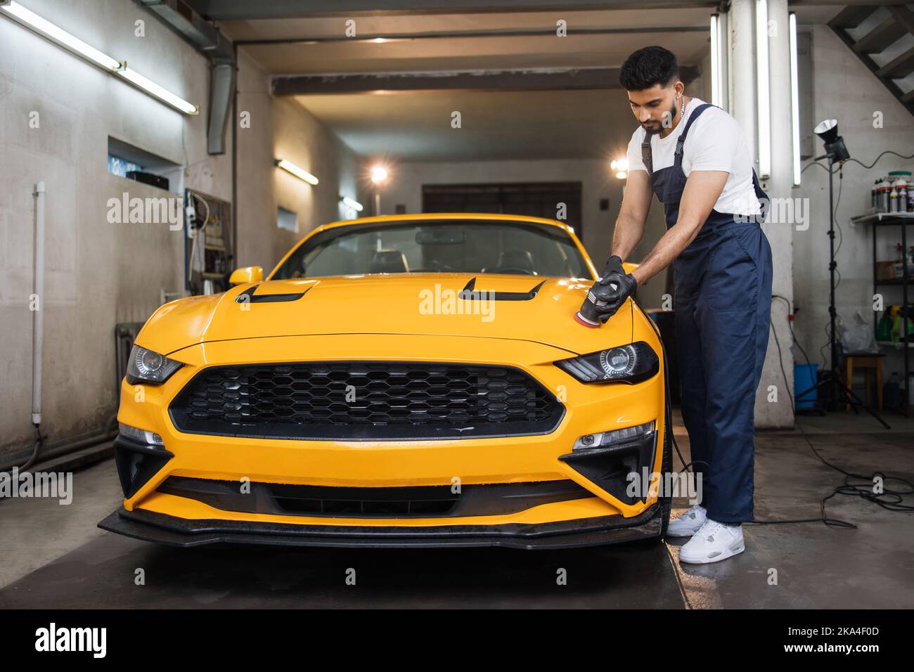 Full length portrait of young handsome man, worker of auto detailing ...