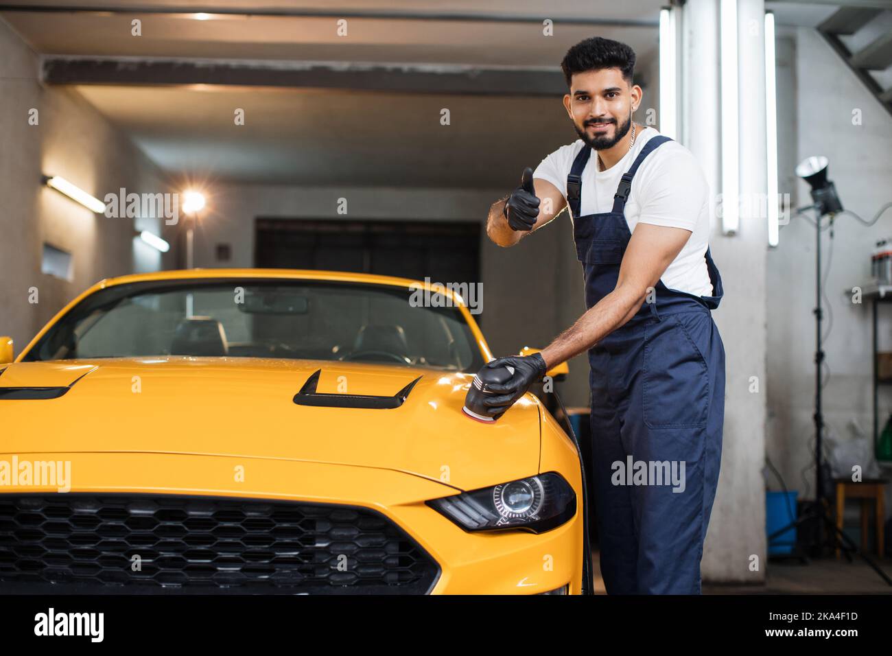 Full length portrait of young handsome man, worker of auto detailing ...