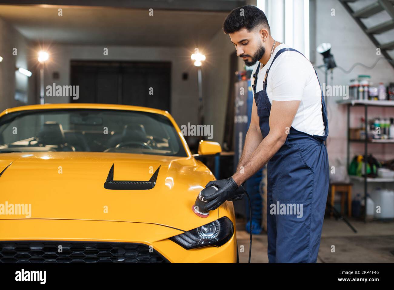 Full length portrait of young handsome man, worker of auto detailing ...
