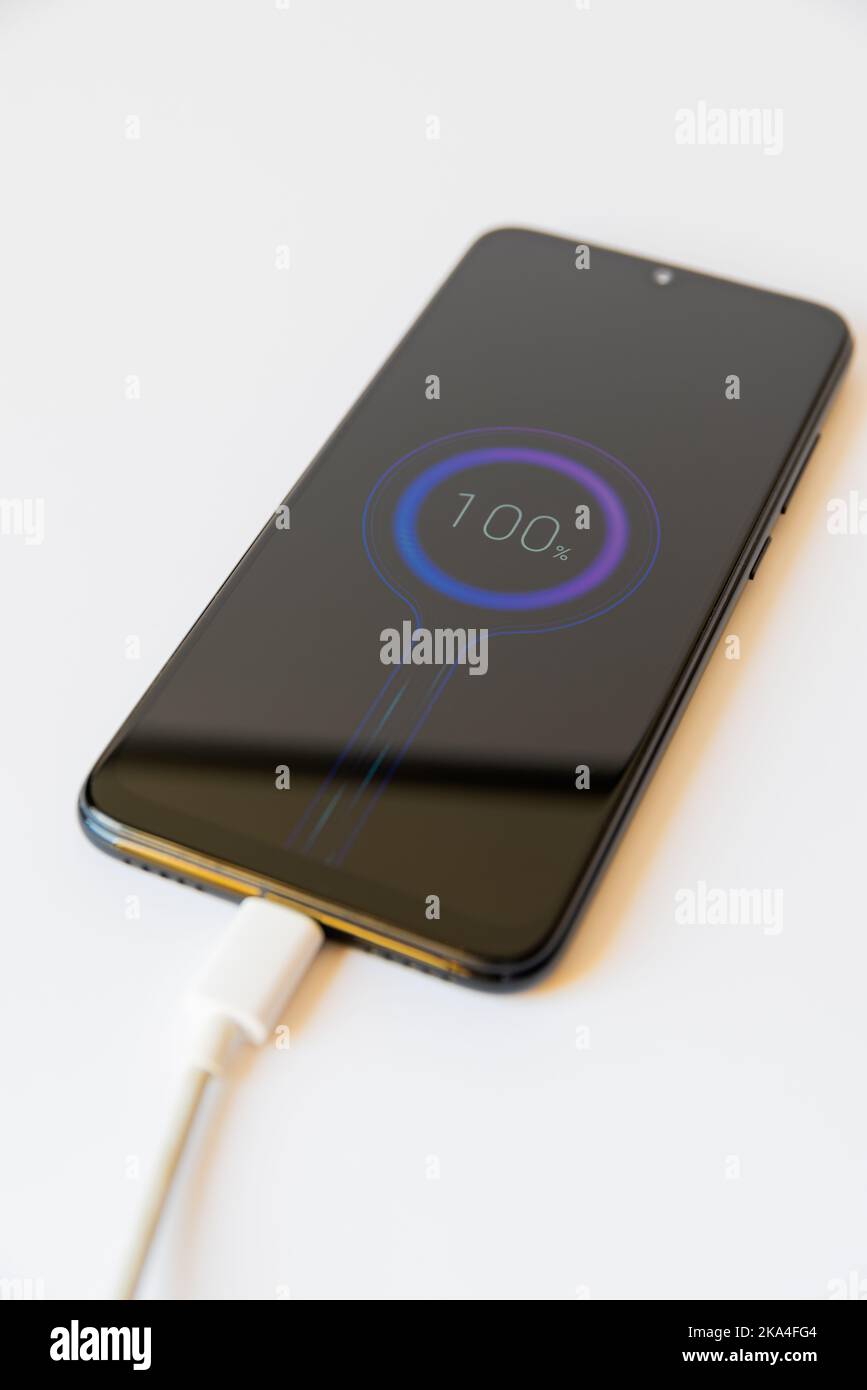 Mobile phone charging with 100 percent battery isolated on white ...