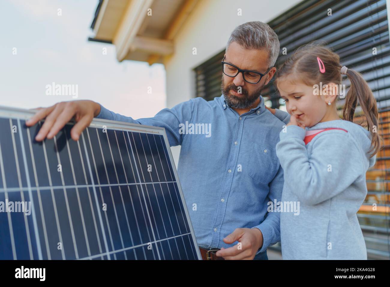 Father showing his little daughter solar photovoltaics panels ...